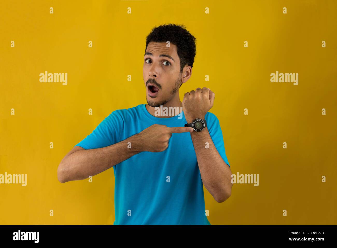 Adult man pointing at his watch on his wrist. Handsome Black Man with ...