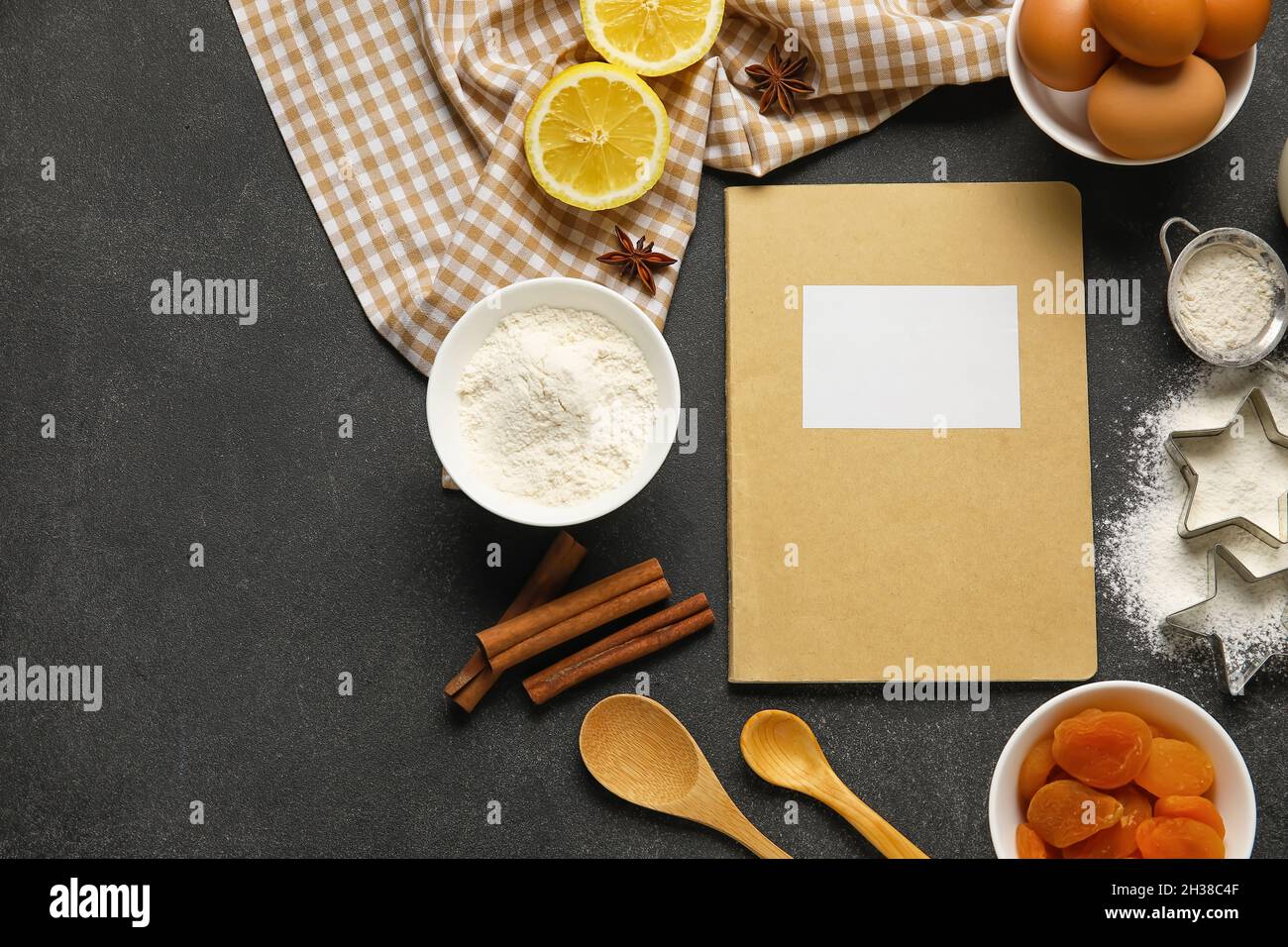 Recipe book, different ingredients and kitchen utensils on dark ...
