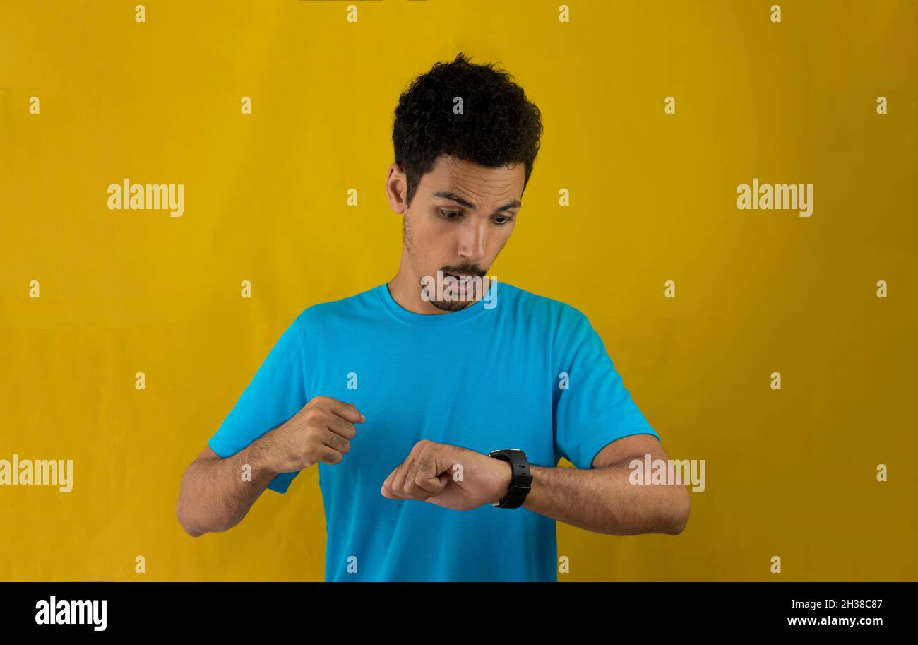 Man looking at his watch on his wrist. Handsome Black Man with blue ...