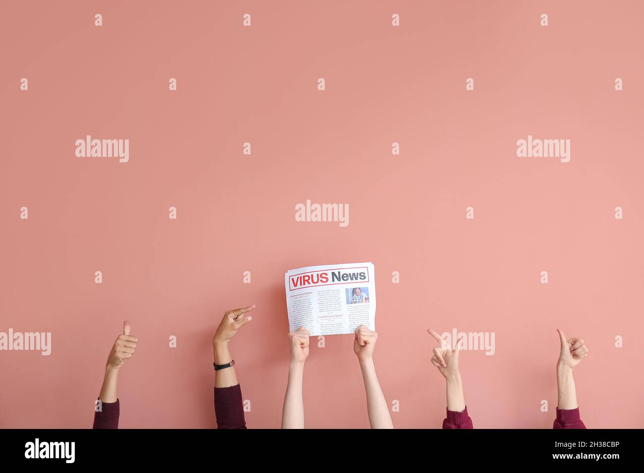 People pointing at newspaper and showing thumb-up on pink background ...