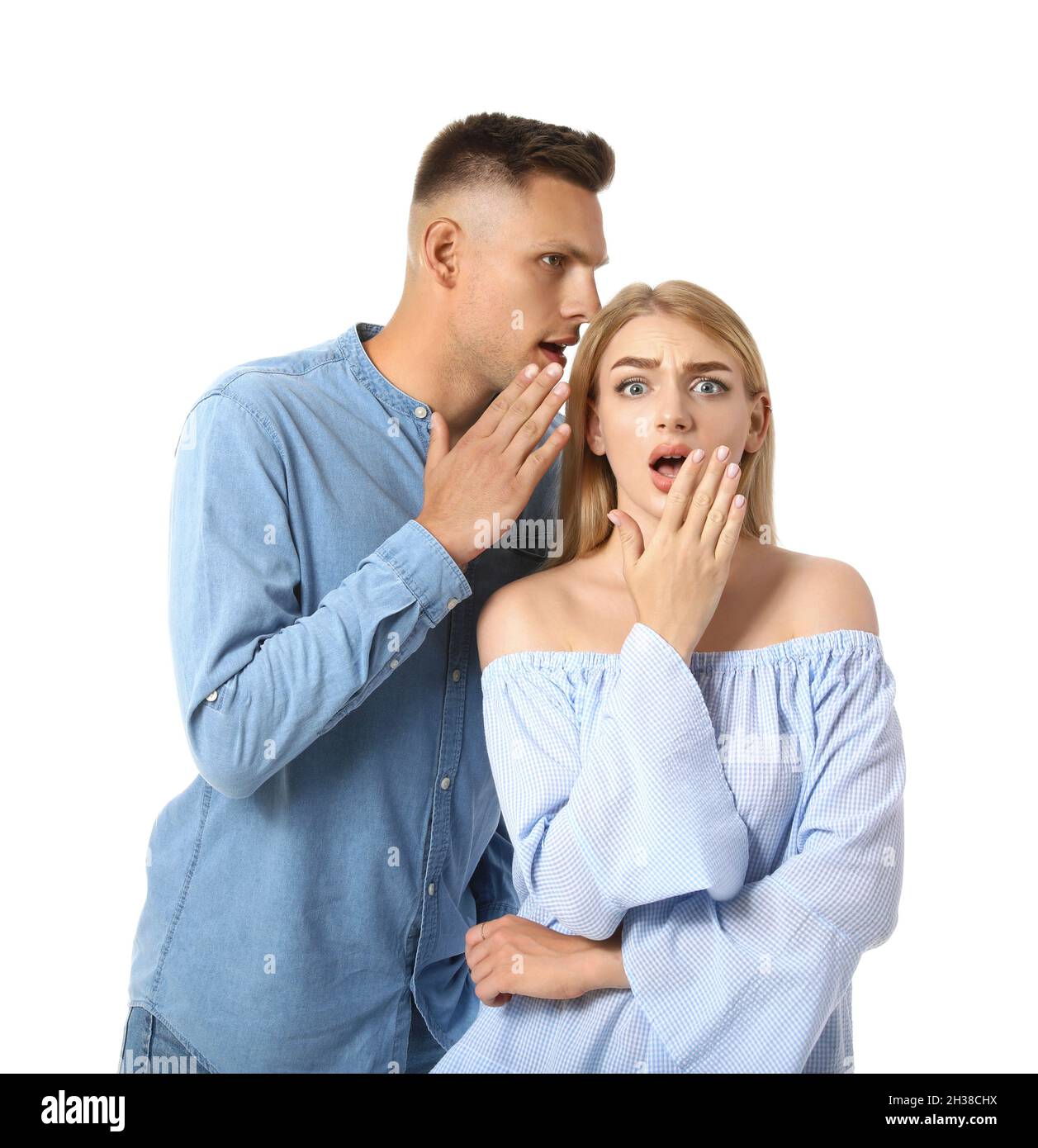 Gossiping young couple on white background Stock Photo - Alamy