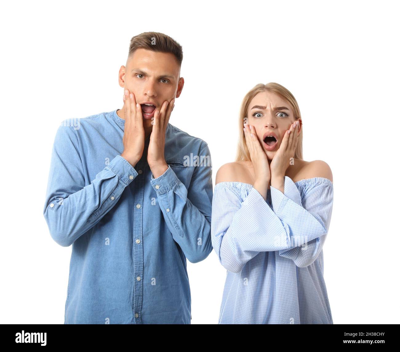 Shocked young couple on white background Stock Photo - Alamy