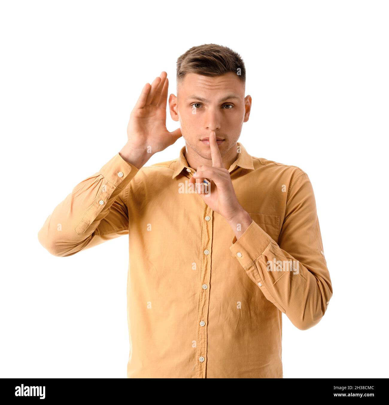 Young man showing silence gesture on white background Stock Photo - Alamy
