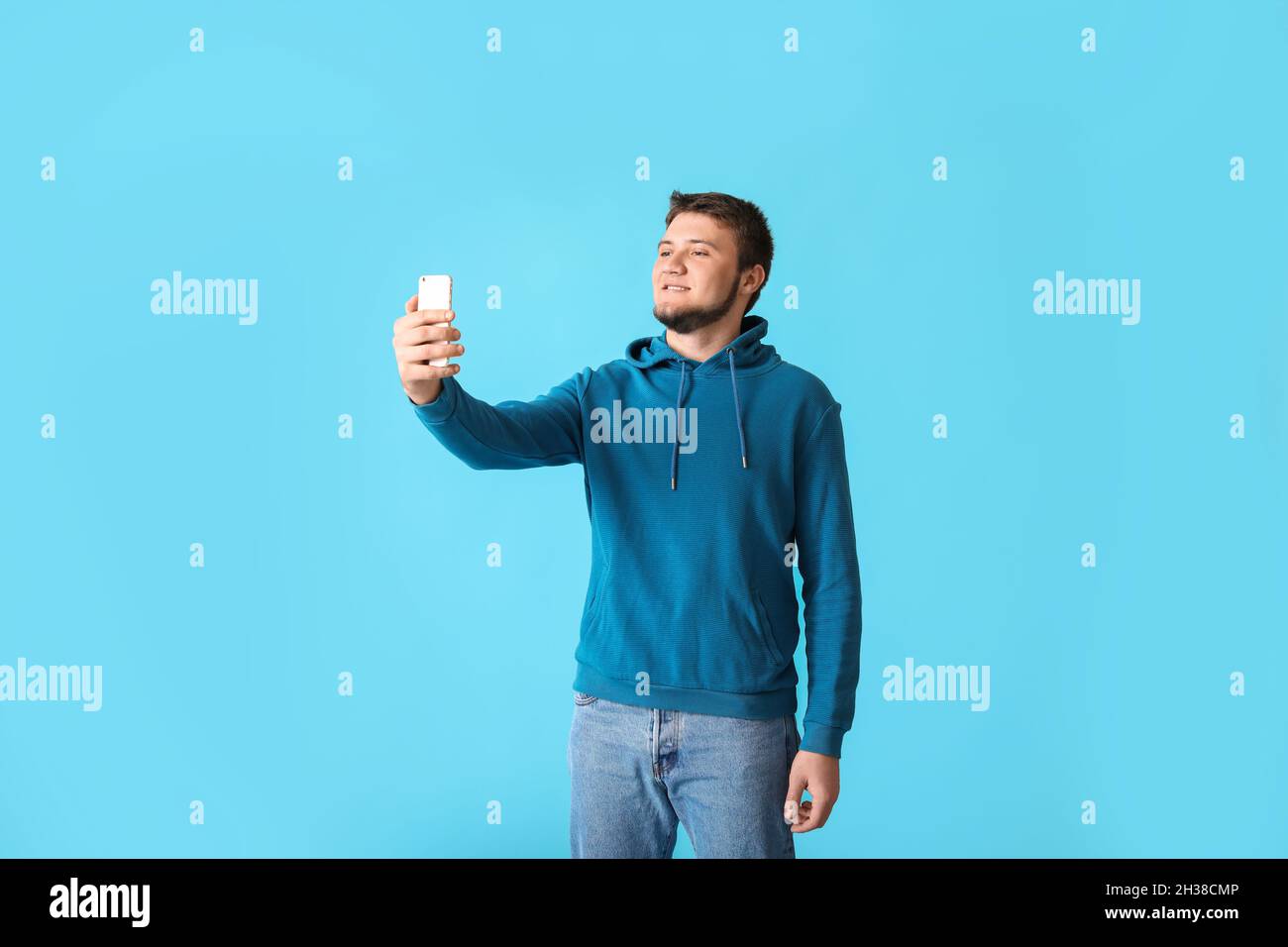Stylish young man taking selfie on color background Stock Photo - Alamy