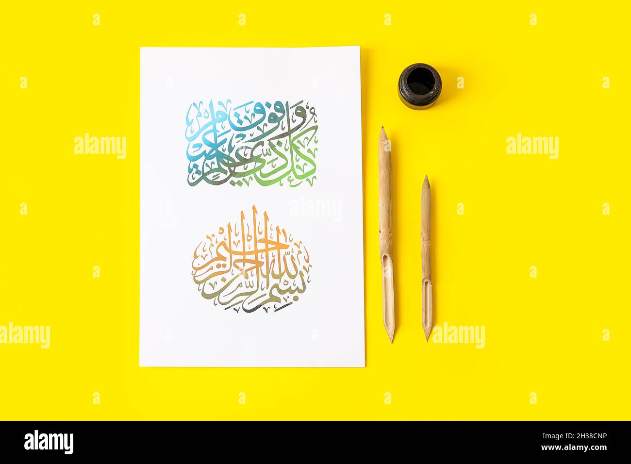 Paper with Arabic text and tools for calligraphy on color background ...