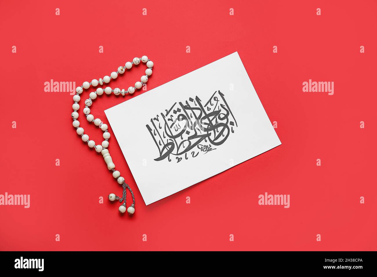 Paper with Arabic text and tasbih on color background Stock Photo - Alamy