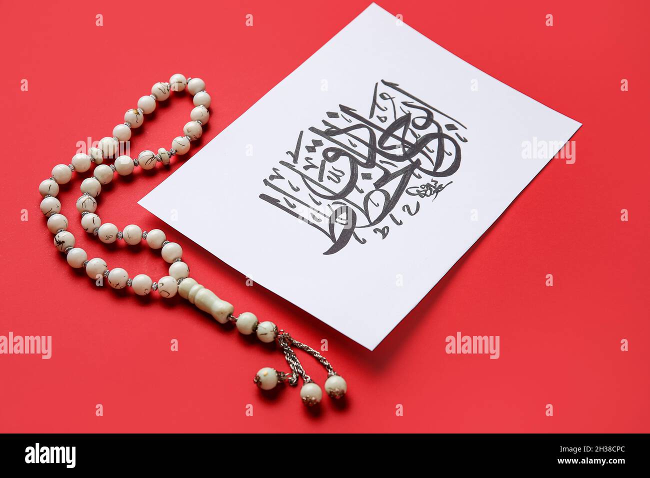 Paper with Arabic text and tasbih on color background Stock Photo - Alamy