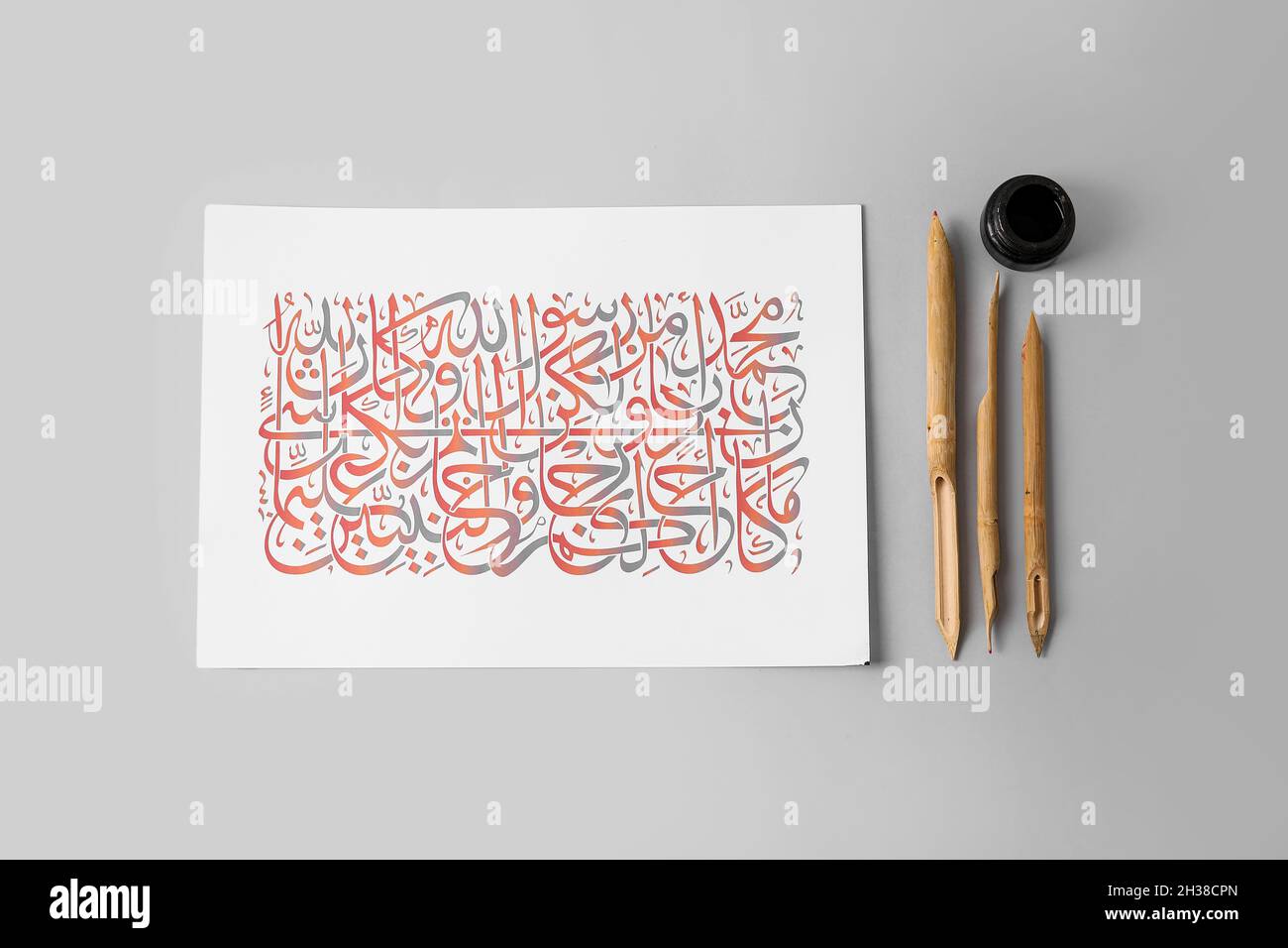 Paper with Arabic text and tools for calligraphy on light background ...