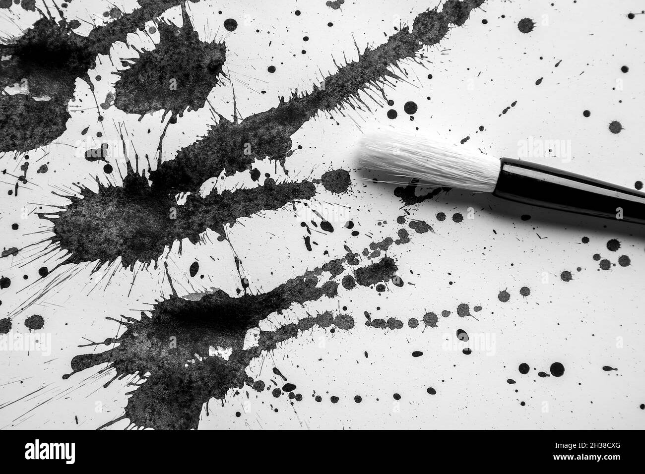 Ink spots and brush for calligraphy on white paper Stock Photo - Alamy