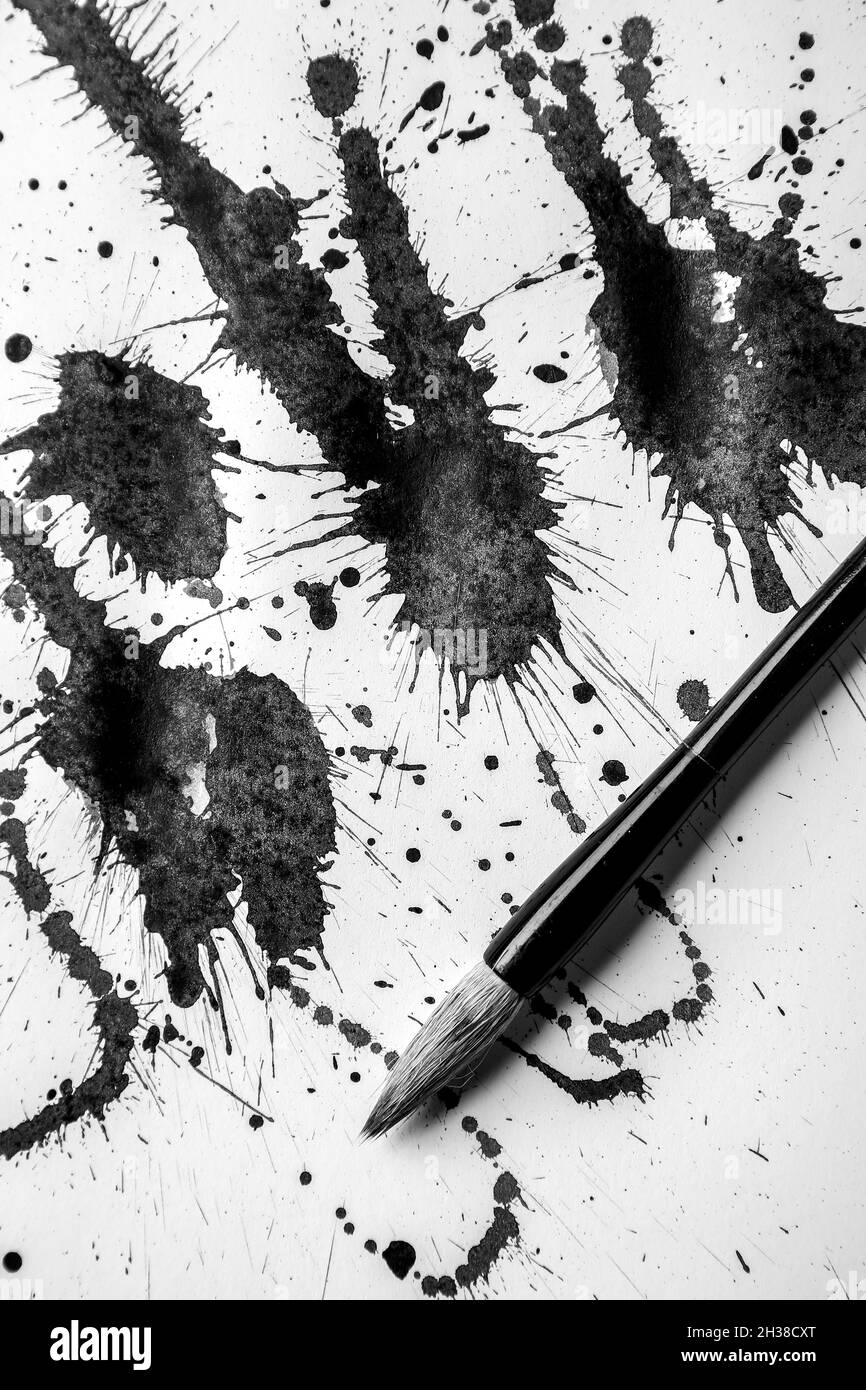 Ink spots and brush for calligraphy on white paper Stock Photo - Alamy