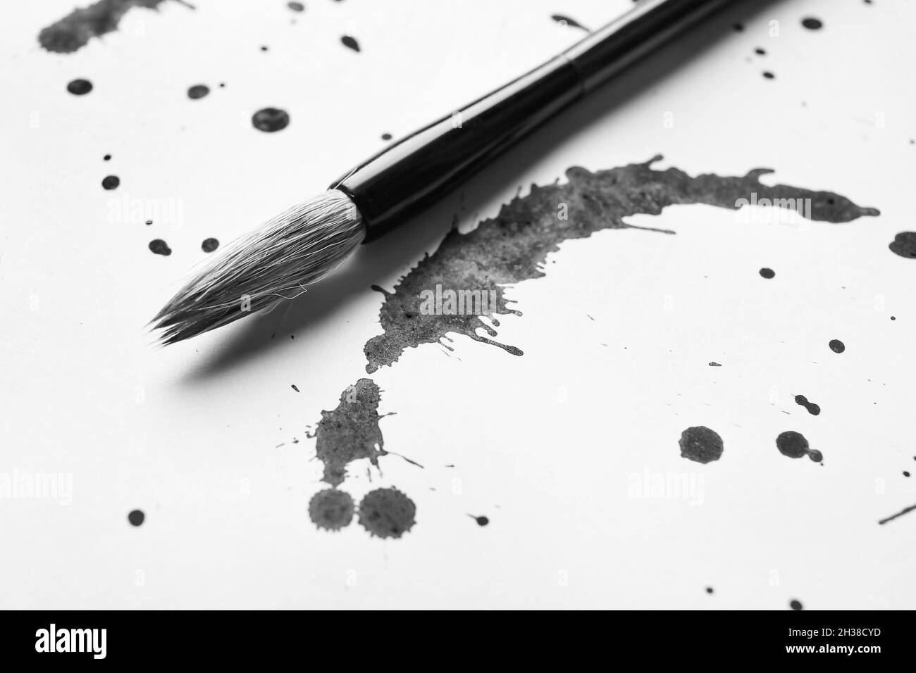 Ink spots and brush for calligraphy on white paper Stock Photo - Alamy