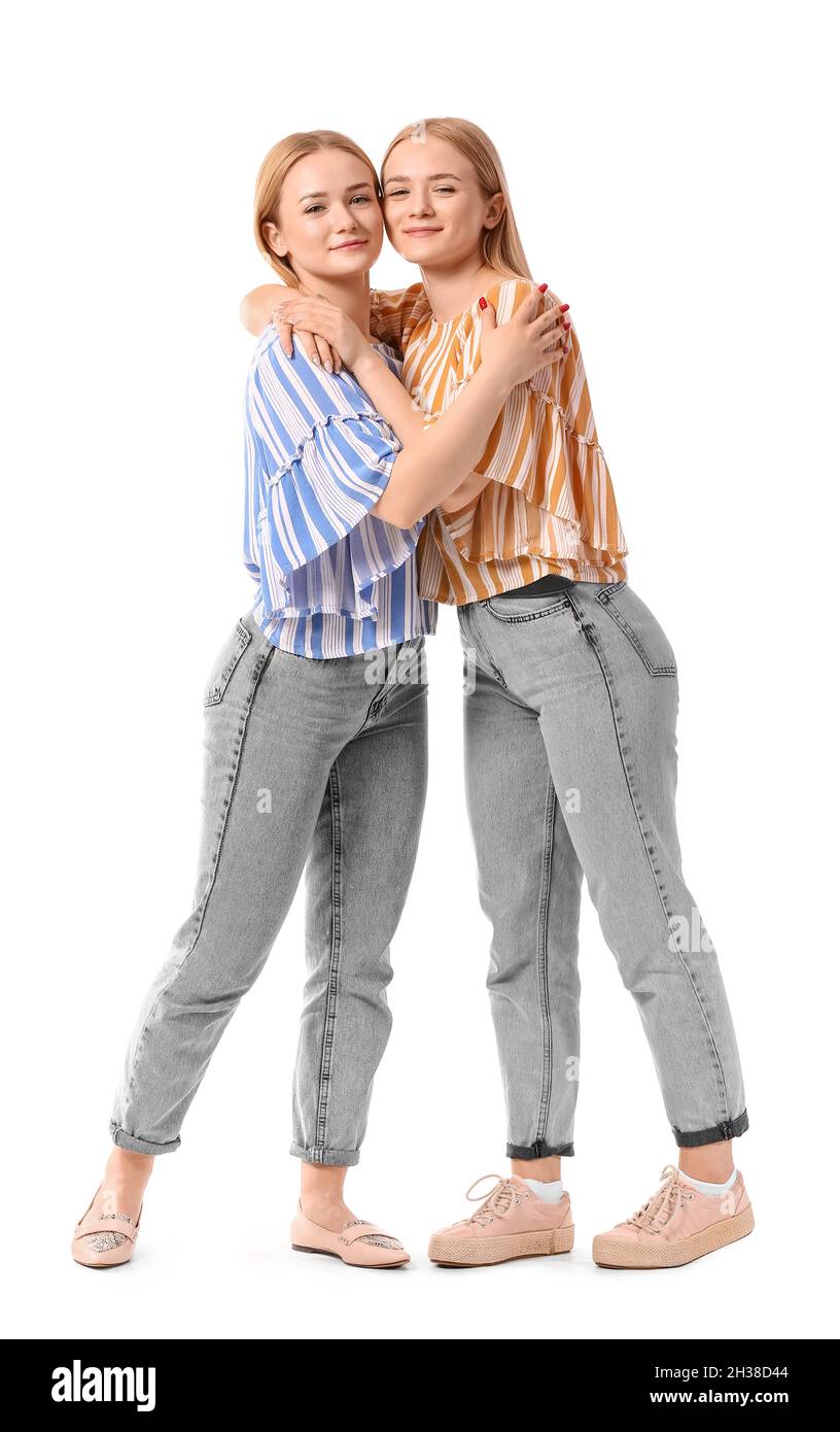 Beautiful young twin sisters hugging on white background Stock Photo ...
