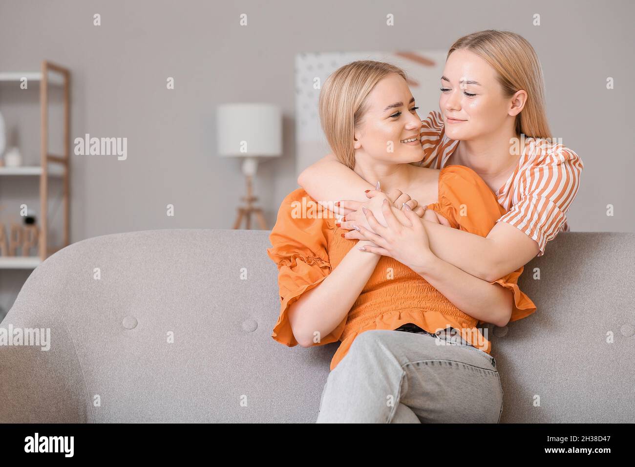 Young woman hugging her twin sister at home Stock Photo - Alamy