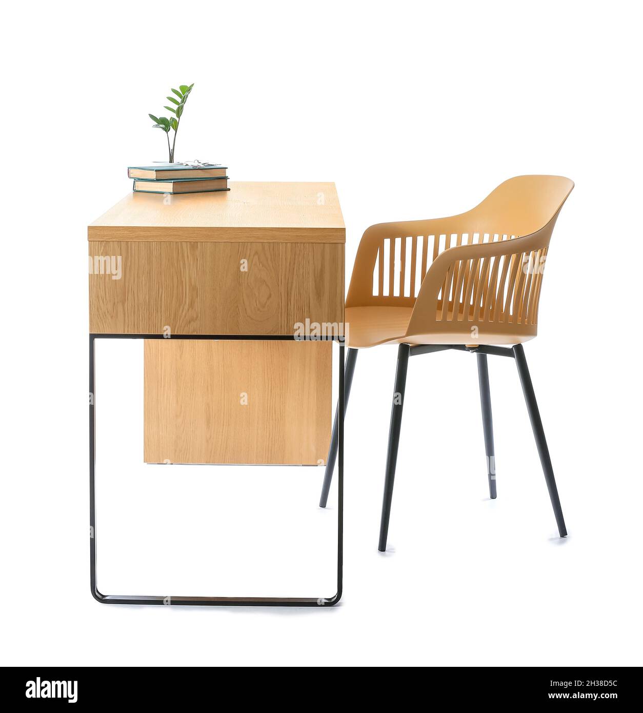 Modern wooden table with books, houseplant and chair on white ...