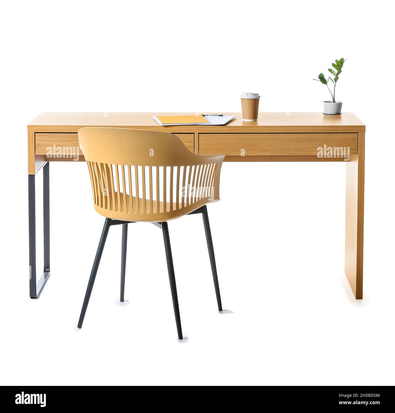 Wooden table with notebooks, paper cup of coffee, houseplant and chair ...