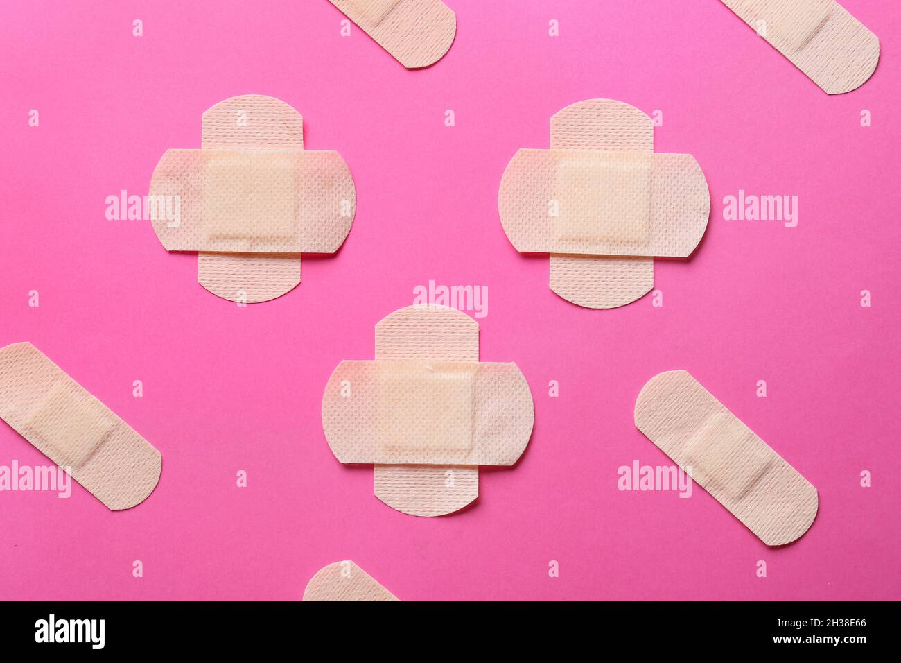 Different elastic medical plasters on pink background Stock Photo - Alamy