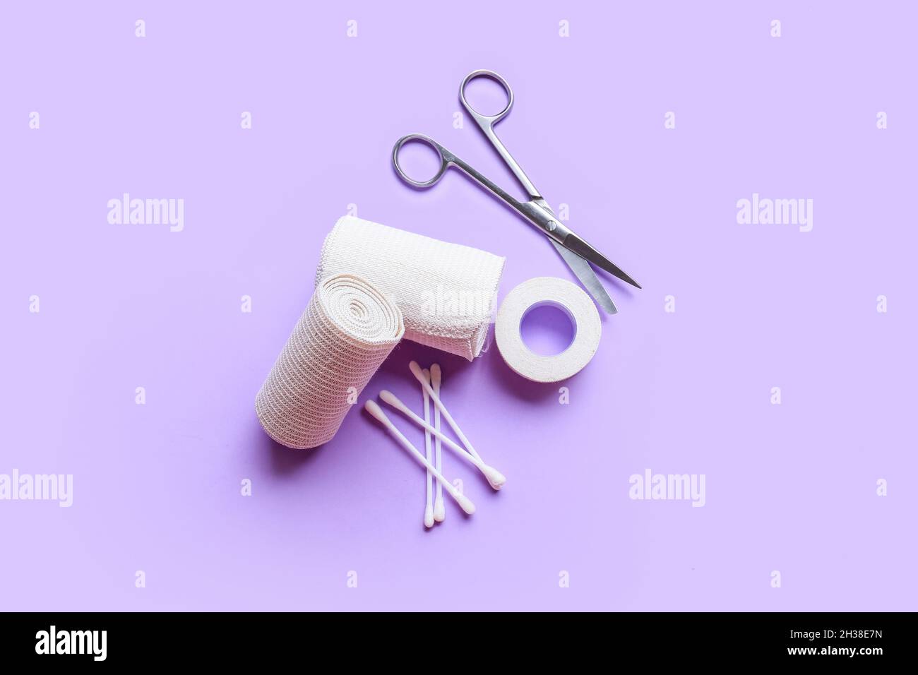 Bandage rolls, cotton buds, medical plaster and surgical scissors on ...
