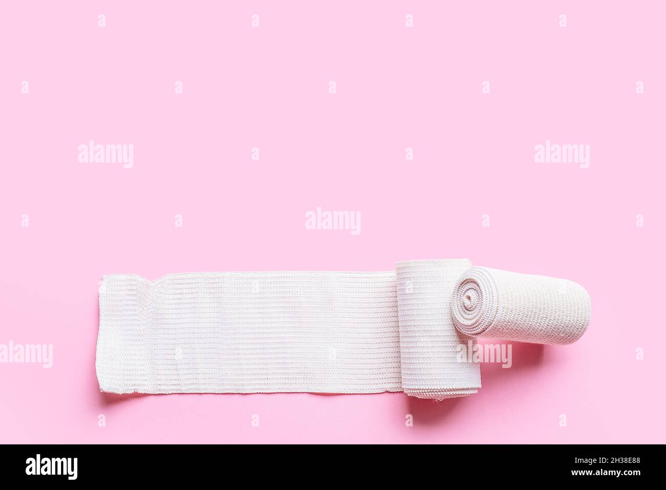 Elastic bandage rolls on pink background Stock Photo - Alamy