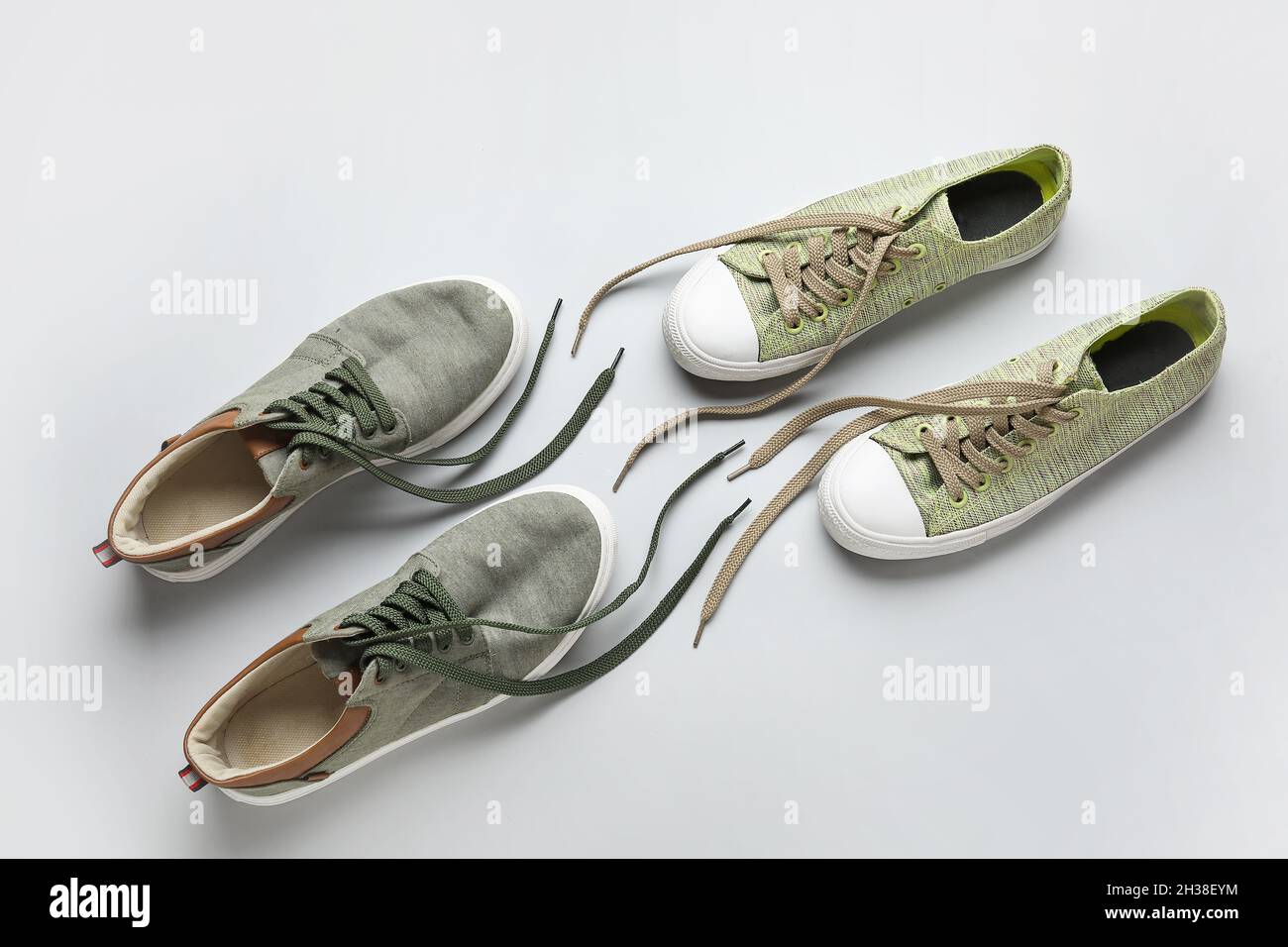 Two pairs of stylish shoes with untied laces on white background Stock ...