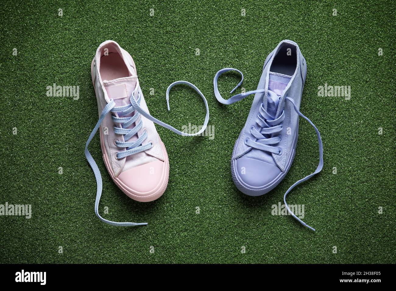 Different shoes with untied laces on color background Stock Photo - Alamy