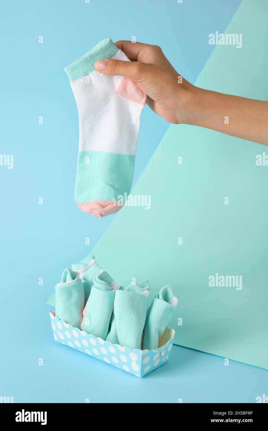 Woman holding sock on color background, closeup Stock Photo - Alamy