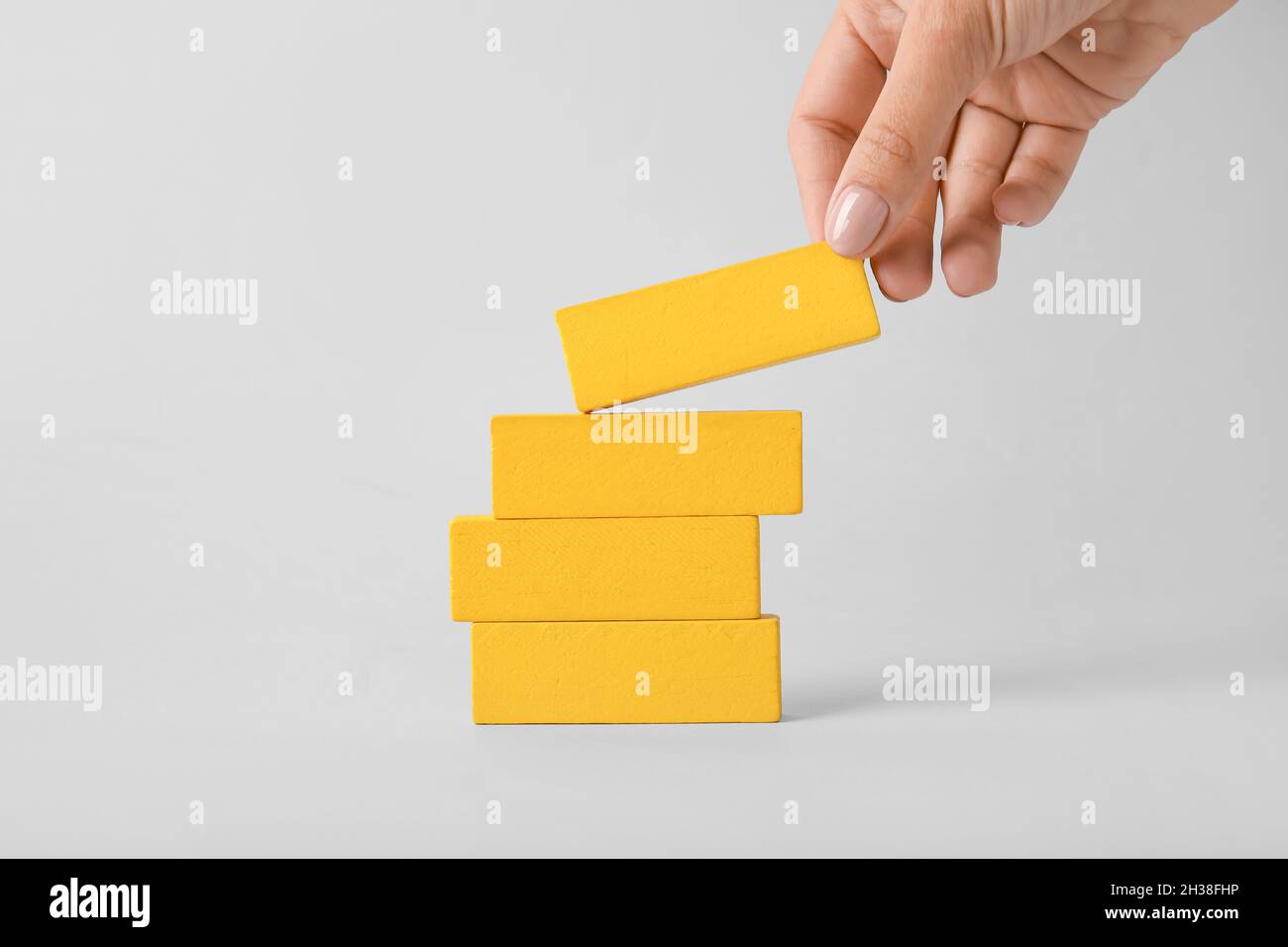 Female hand stacking blocks on light background Stock Photo - Alamy
