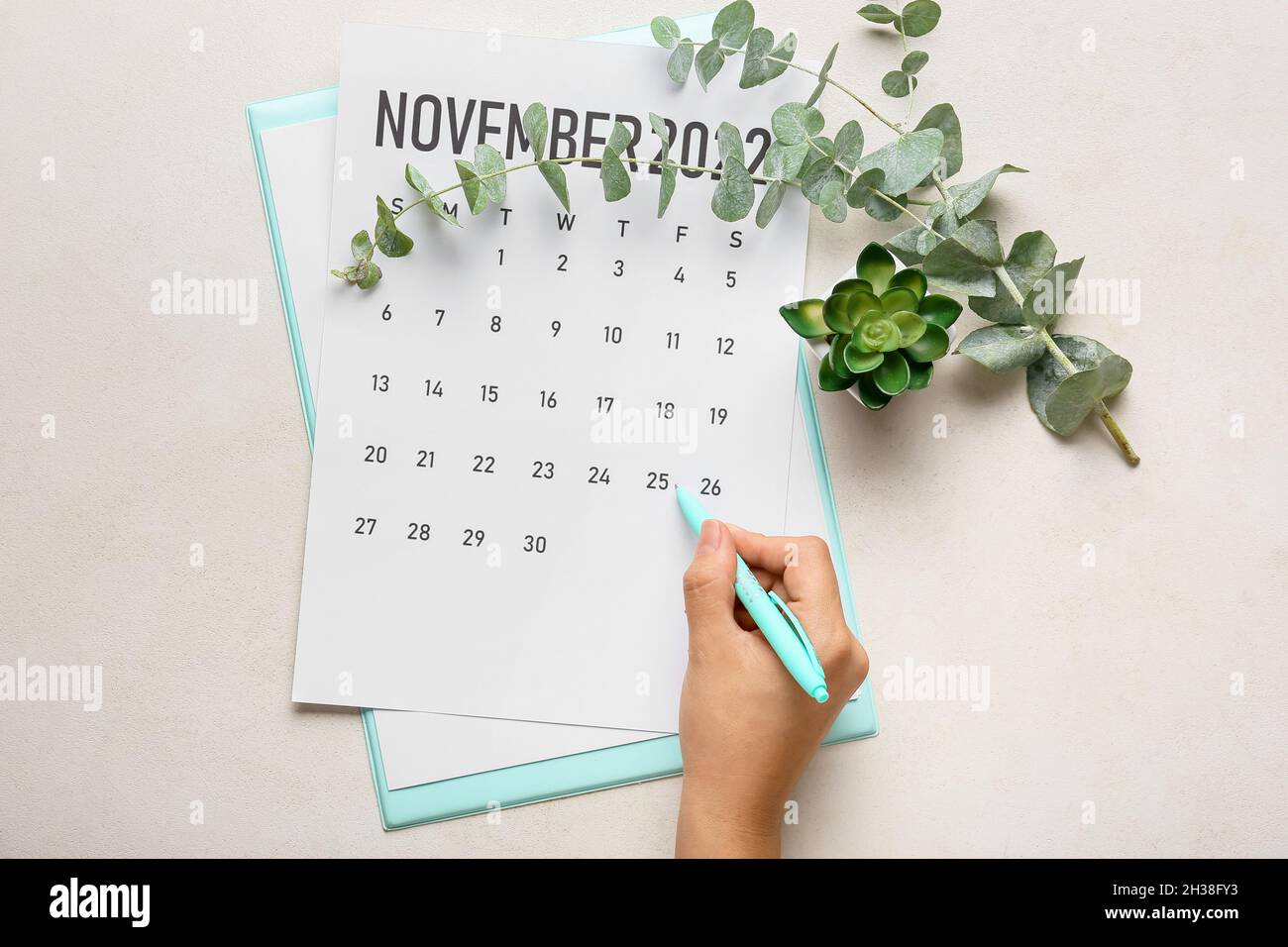 Woman marking date of Black Friday in calendar on white background ...