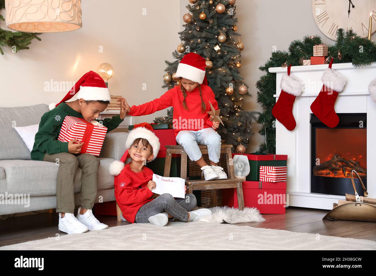 Cute little children with gift and letter to Santa at home on Christmas ...