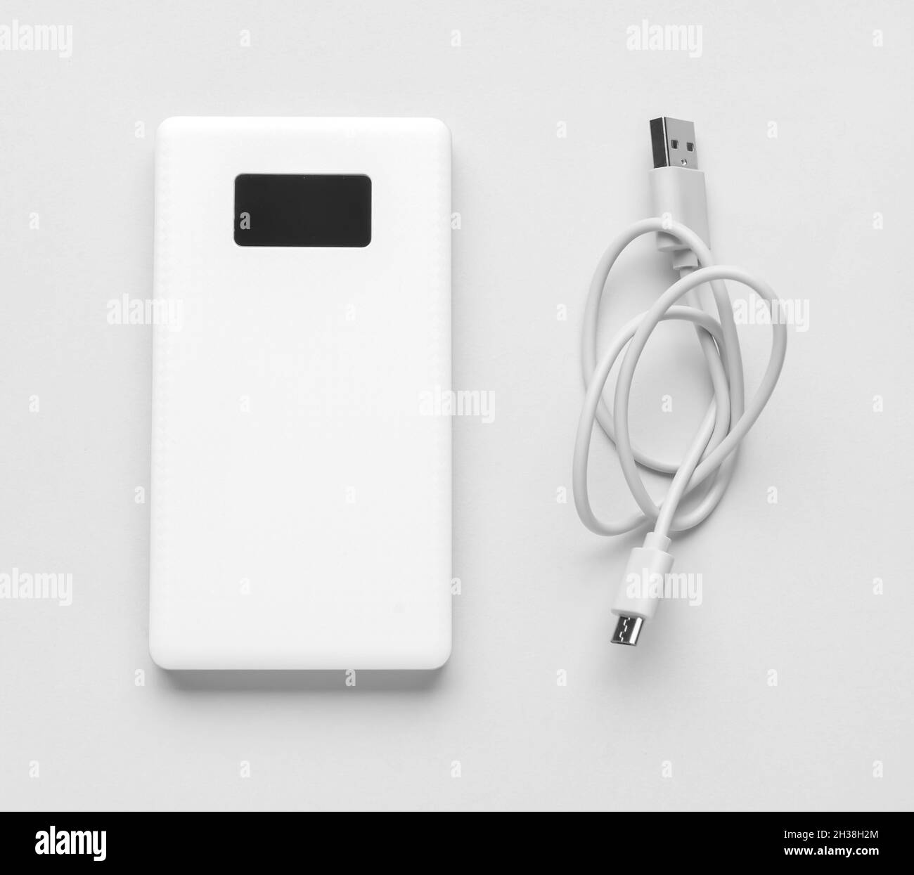 Modern power bank and USB cable on light background Stock Photo - Alamy