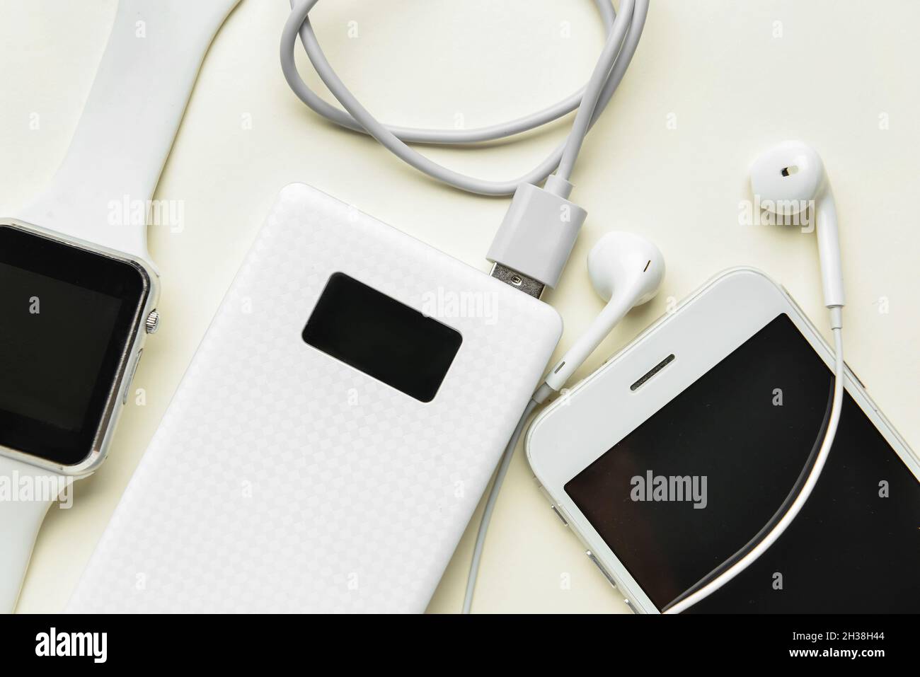 Modern power bank, smartwatch and mobile phone on beige background ...