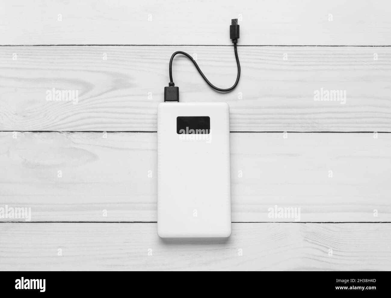 Modern power bank on white wooden background Stock Photo - Alamy