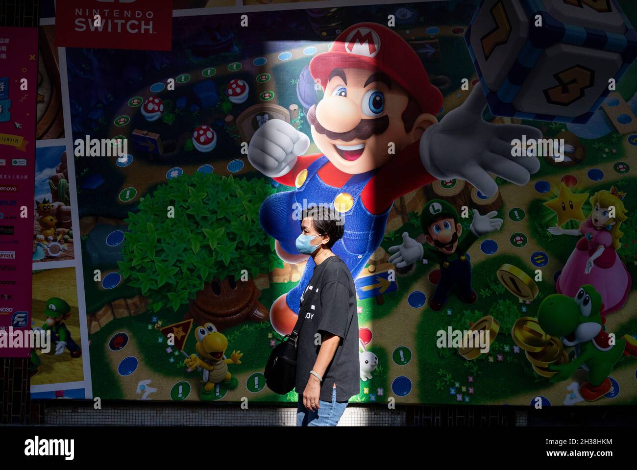 A pedestrian walks past a Nintendo Switch and Mario commercial ...