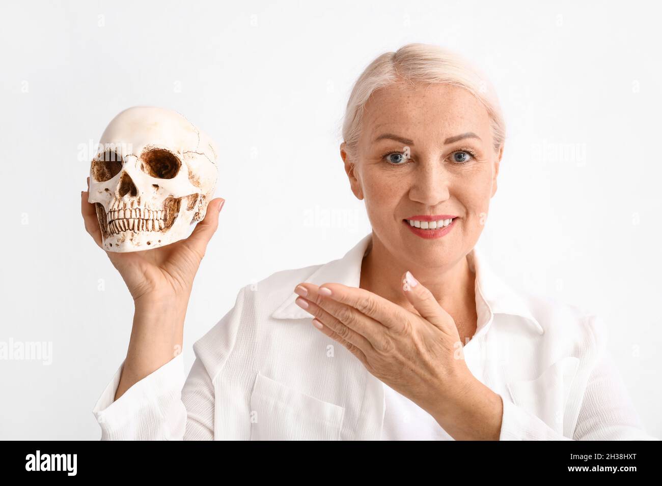 Woman holding human skull on white background Stock Photo - Alamy