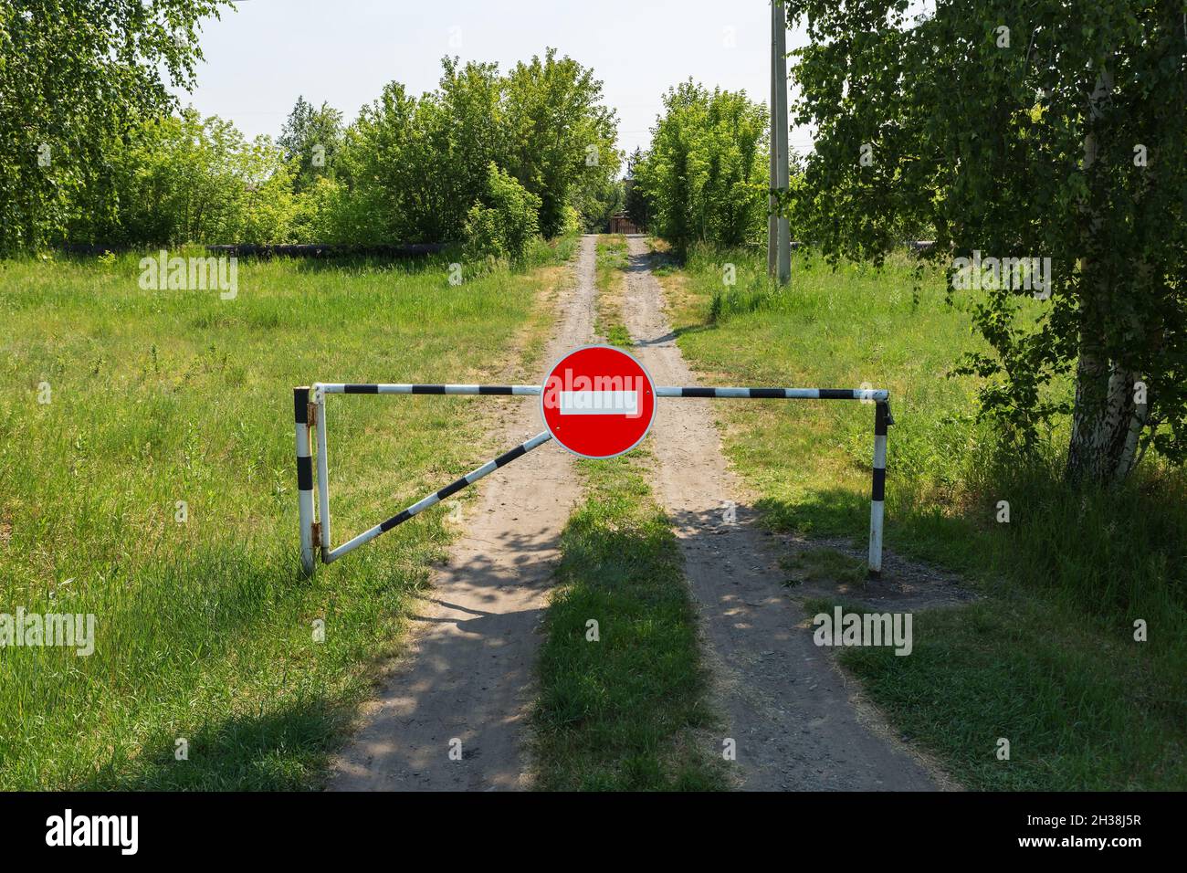 Closed barrier and prohibition sign on the road. The road is closed ...