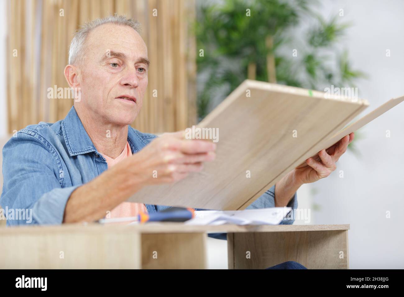 man senior checking a wood table Stock Photo - Alamy