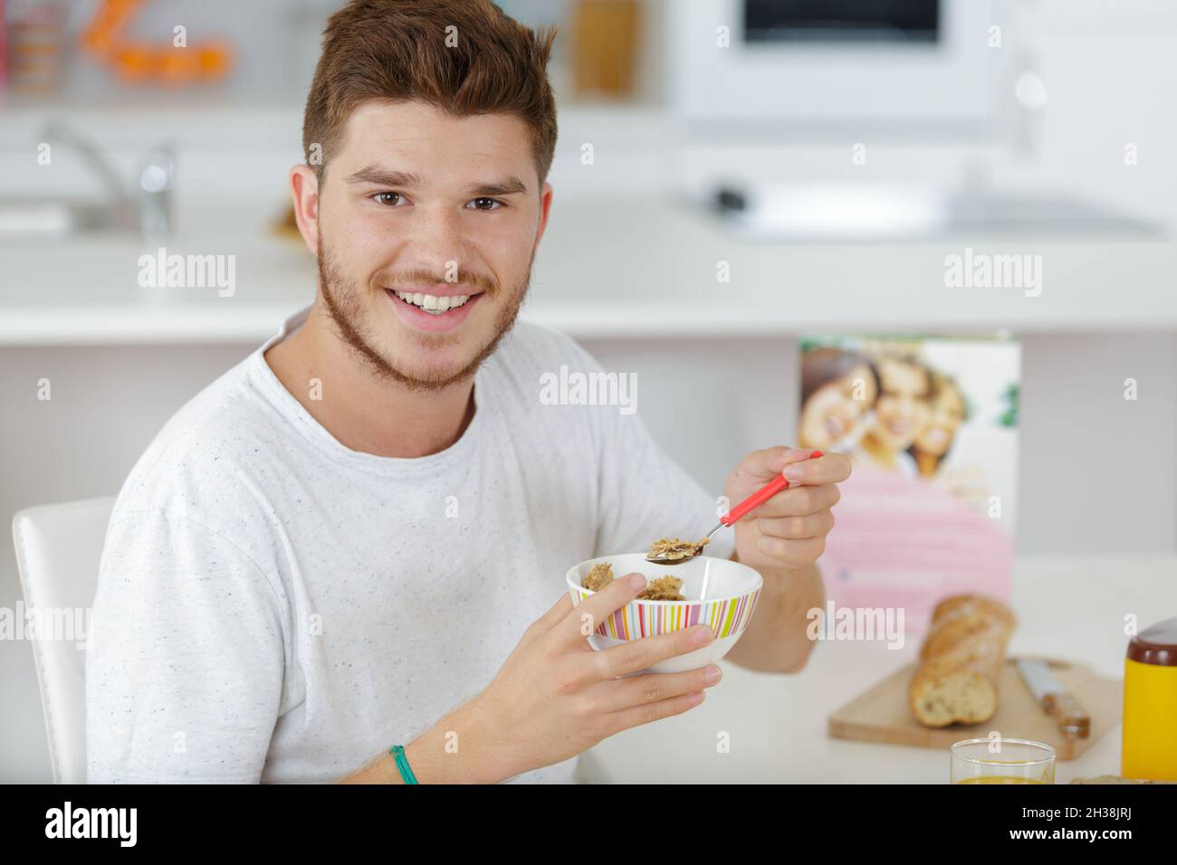 man pouring milk into bowl with muesli Stock Photo - Alamy