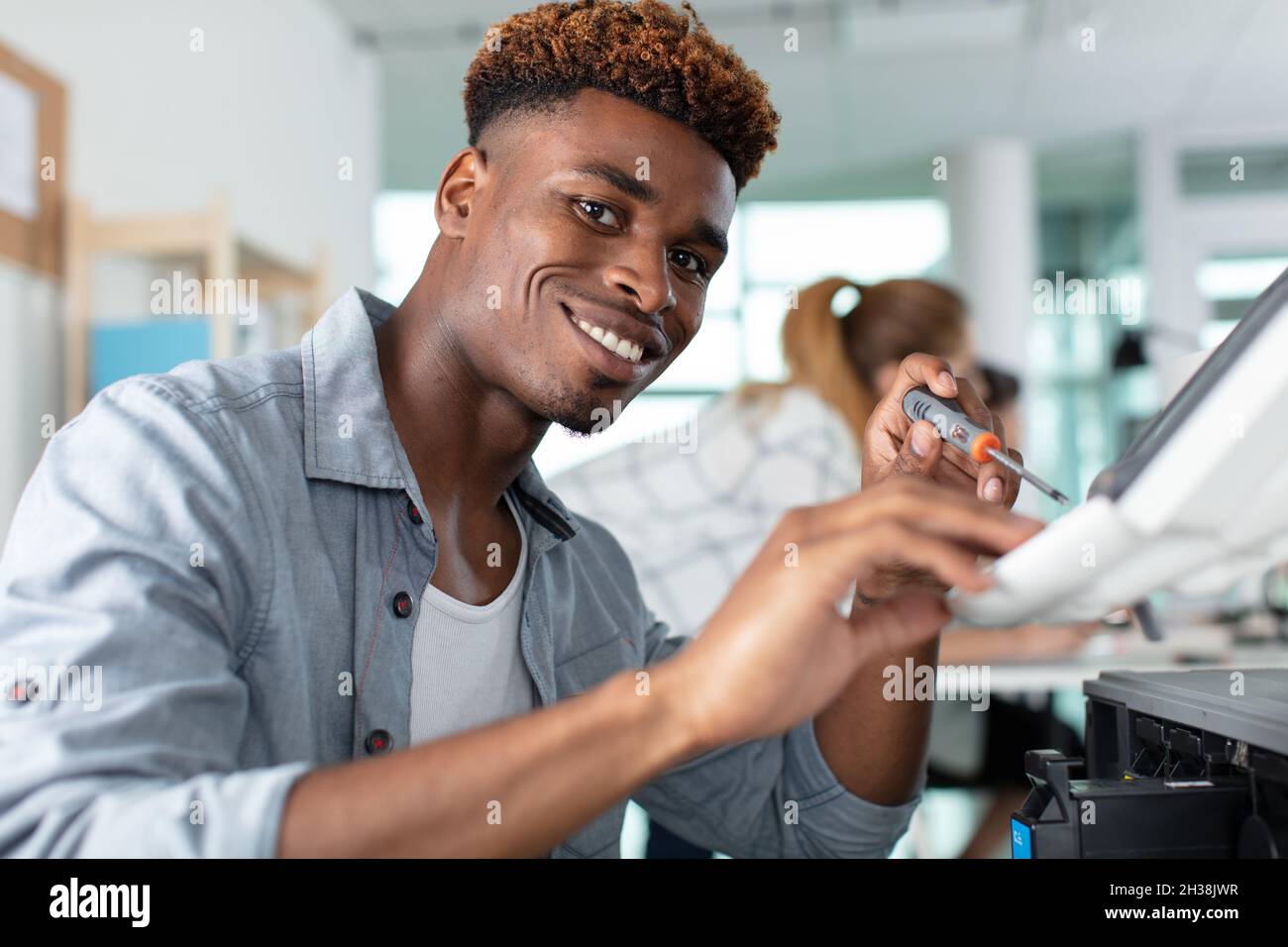happy young man fixing a printer Stock Photo - Alamy