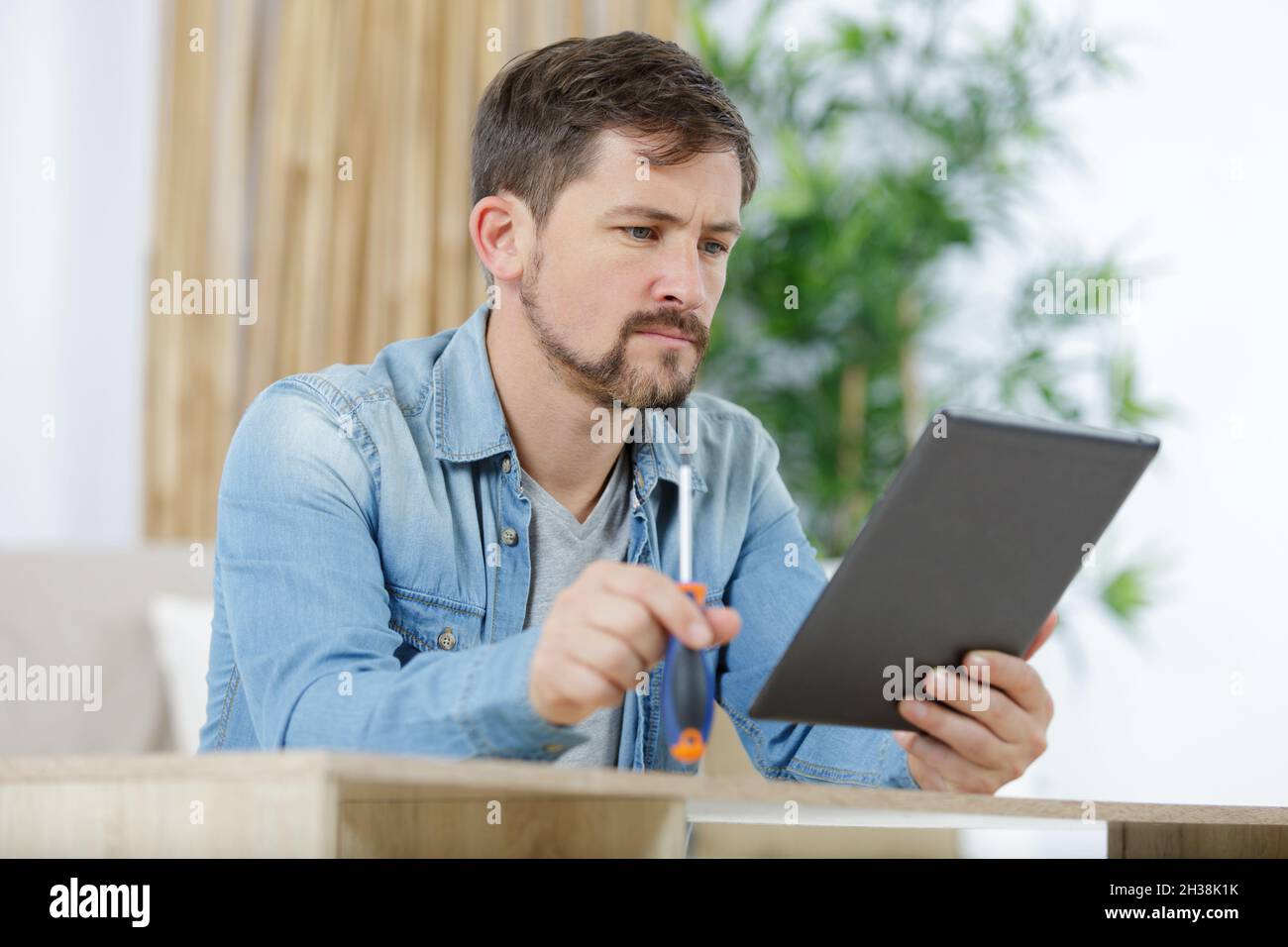 handsome man screw a furniture Stock Photo - Alamy