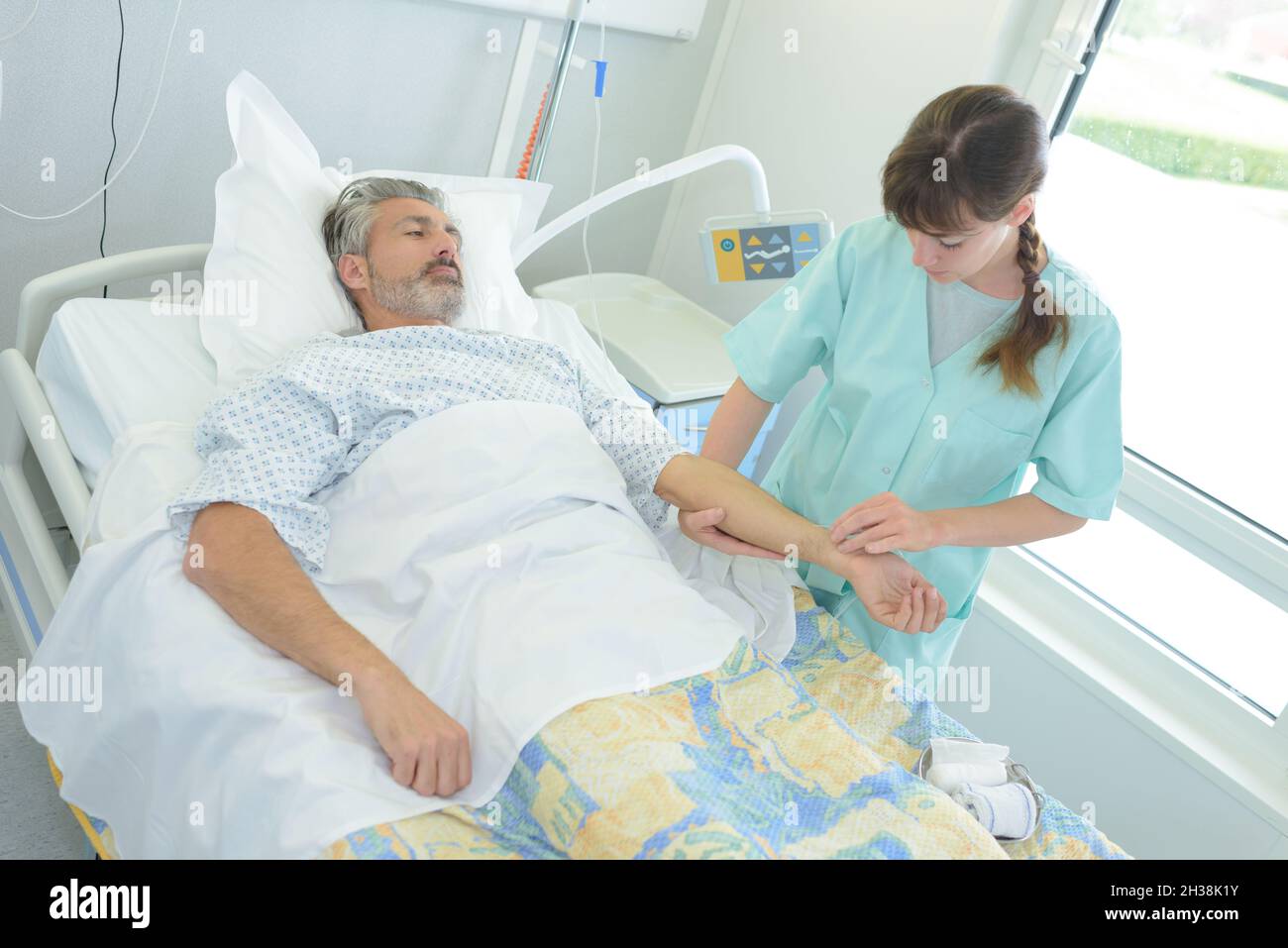 nurse taking pulse of patient in hospital bed Stock Photo - Alamy
