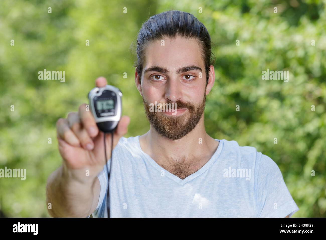 portrait of young man holding a digital stopwatch Stock Photo - Alamy