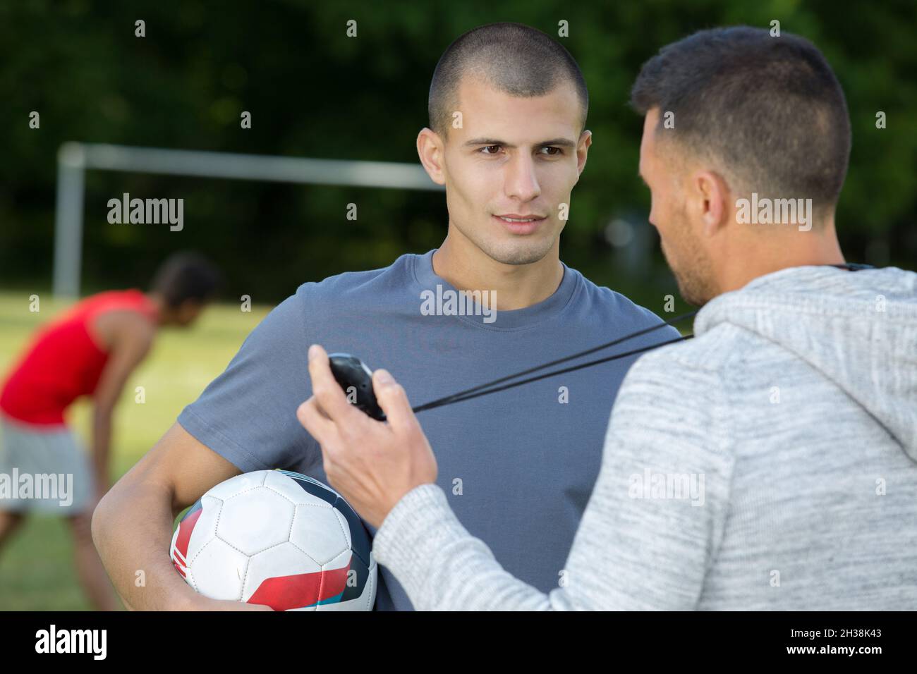 soccer ball and coach during training Stock Photo - Alamy