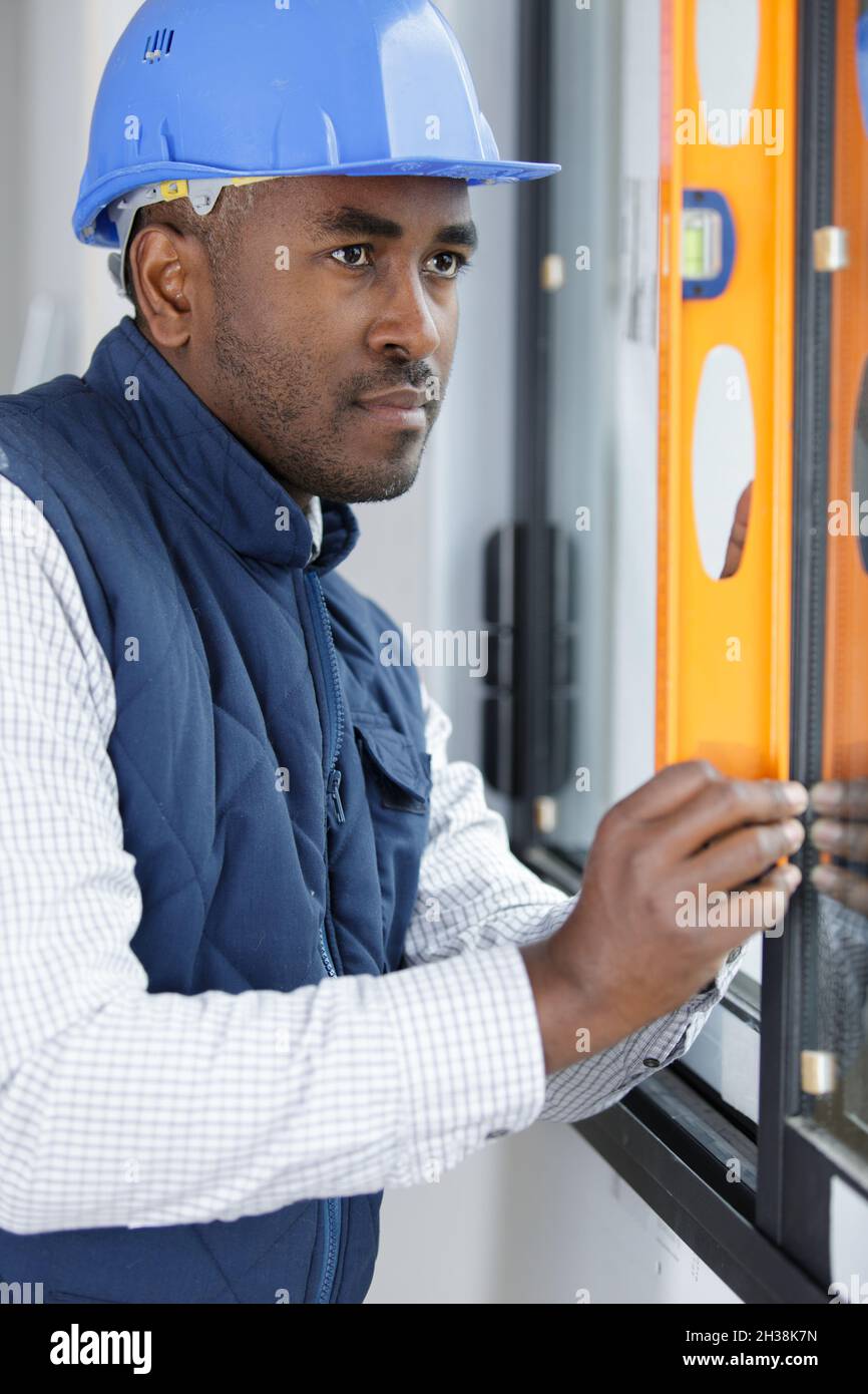 contractor using a spirit level vertically on a window frame Stock ...
