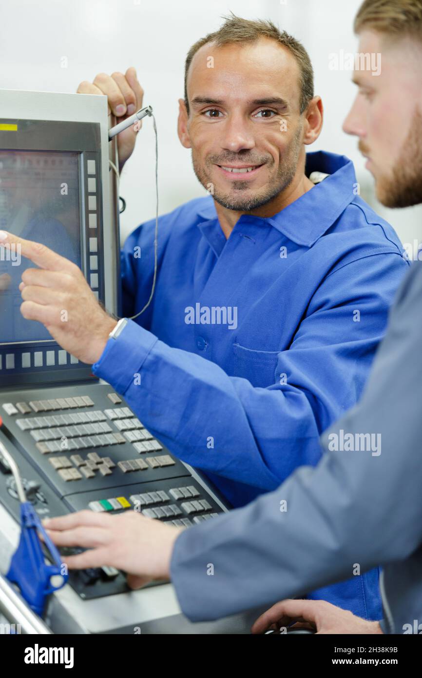 technician pointing to screen of computerised control panel Stock Photo ...