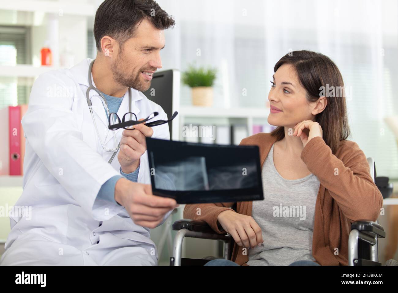 female disabled patient with young doctor Stock Photo - Alamy