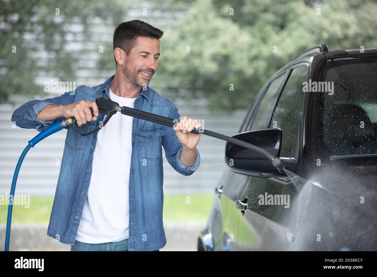 busy man washing his own car at car washing station Stock Photo - Alamy