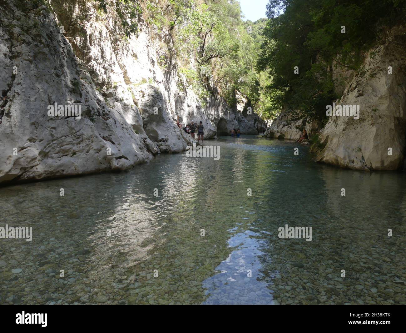 Beautiful closeup view of a lake between two cliffs surrounded by trees ...