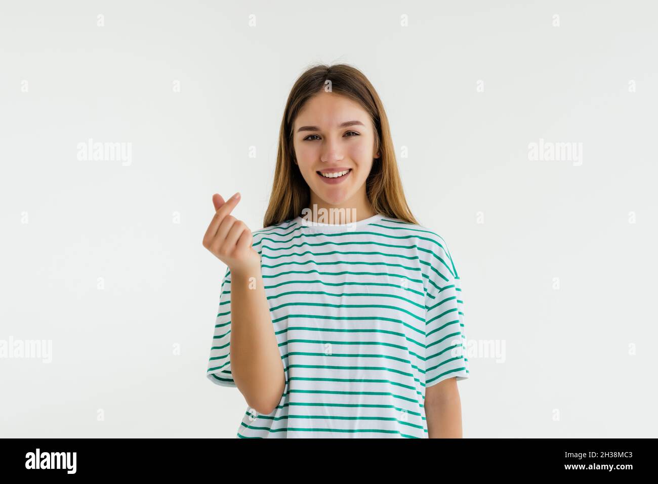 Portrait of smiling young woman with heart shape hand sign Stock Photo ...