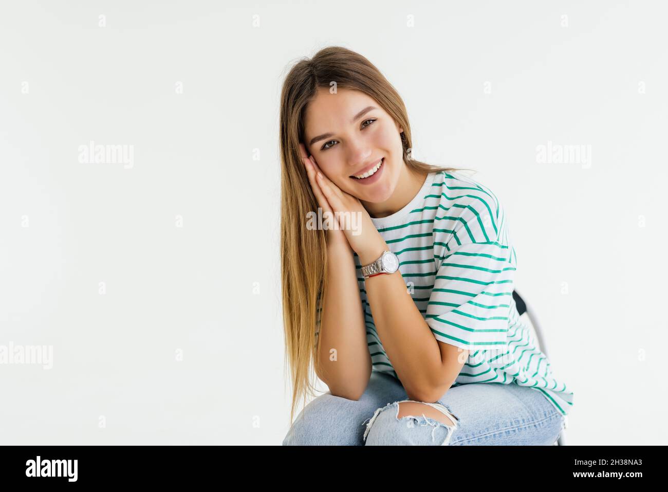 Beautiful woman sitting on a chair and smiling, isolated over white ...