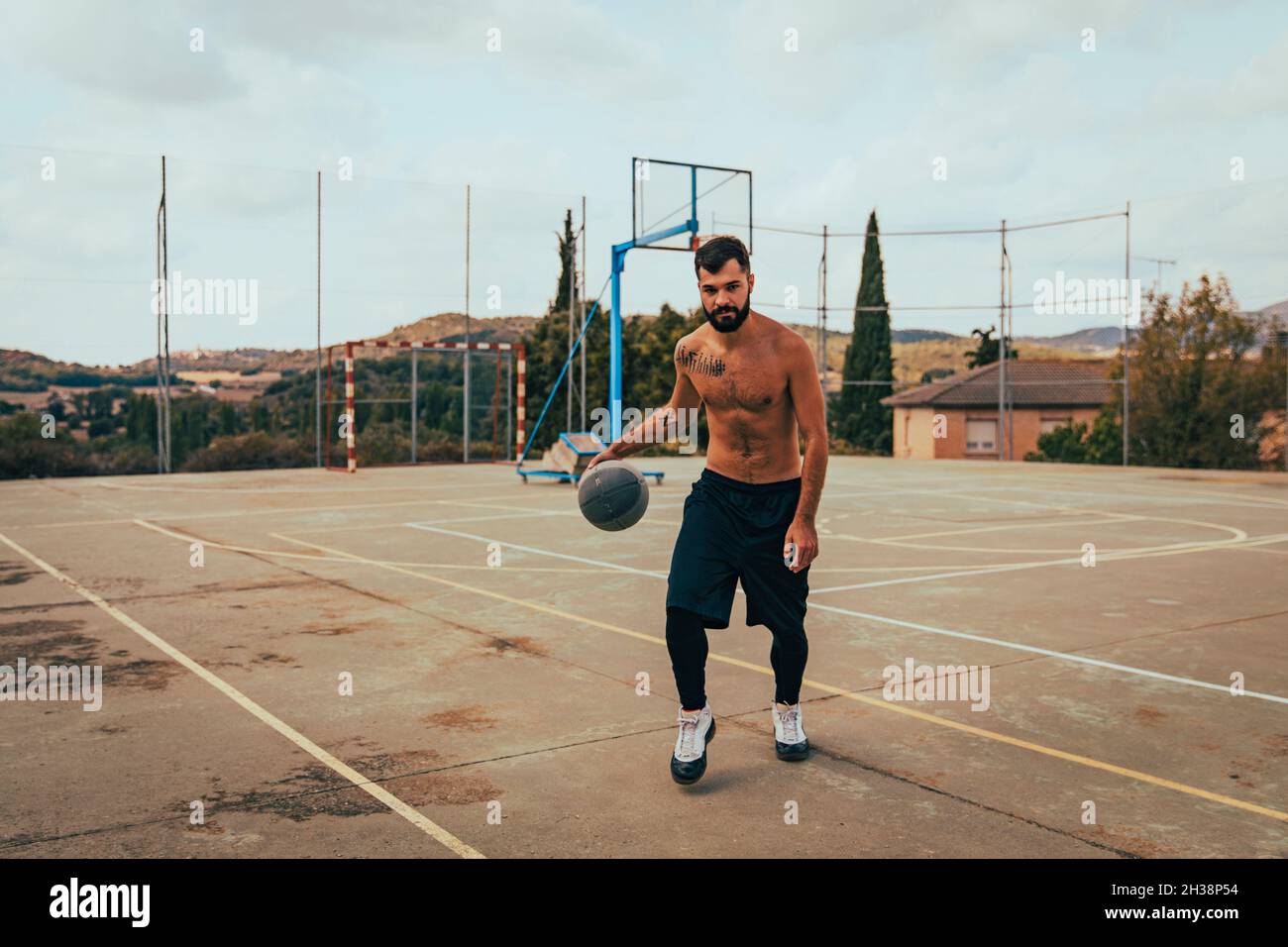 Young boy training alone on a basketball court Stock Photo - Alamy