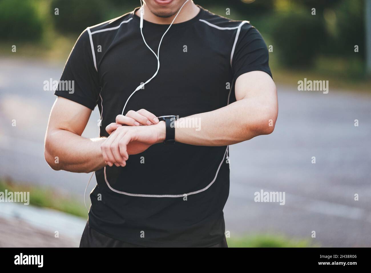Attractive young fitness man using smartwatch Stock Photo - Alamy